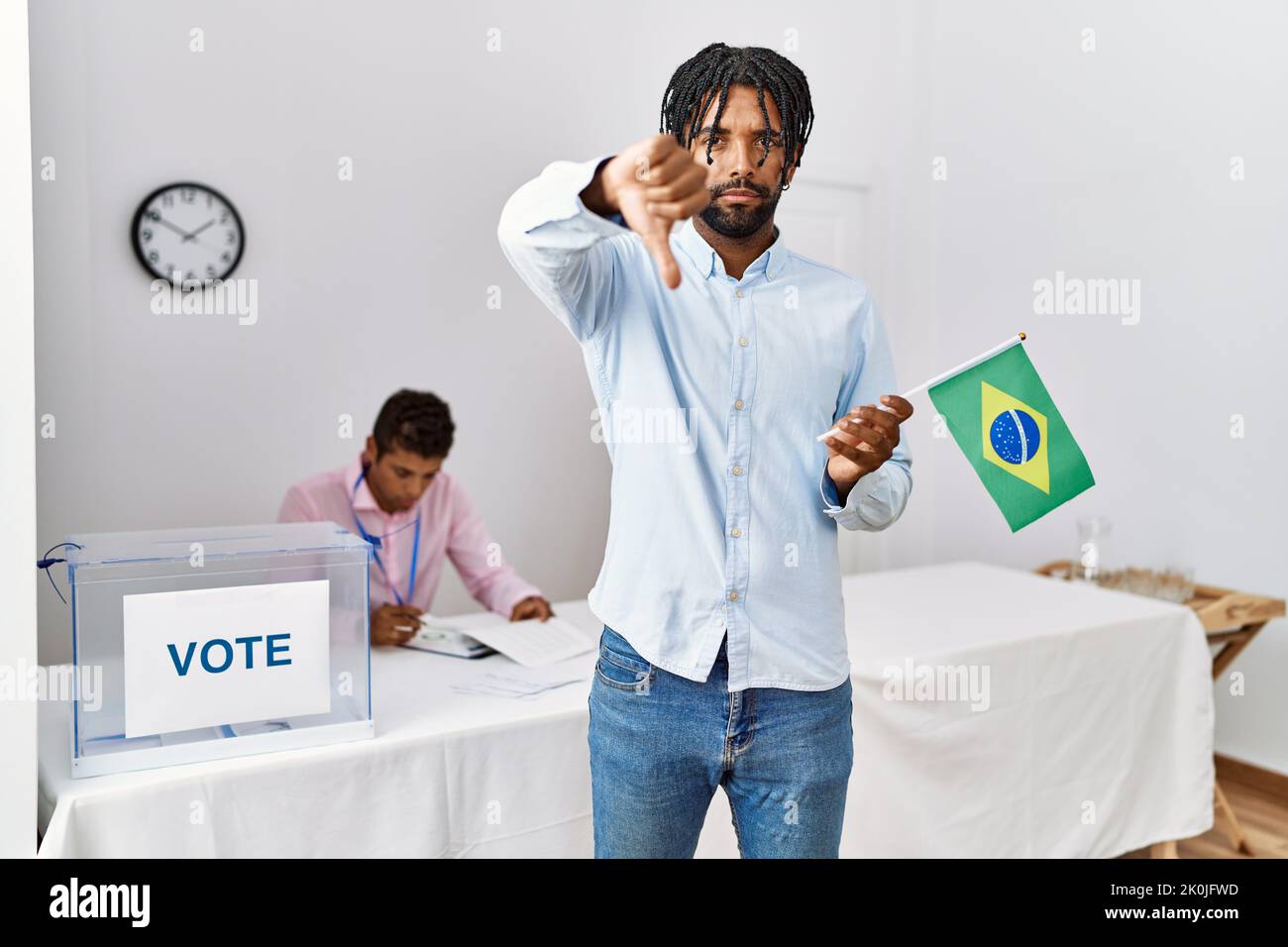 Young hispanic men at political campaign election holding brazil flag ...