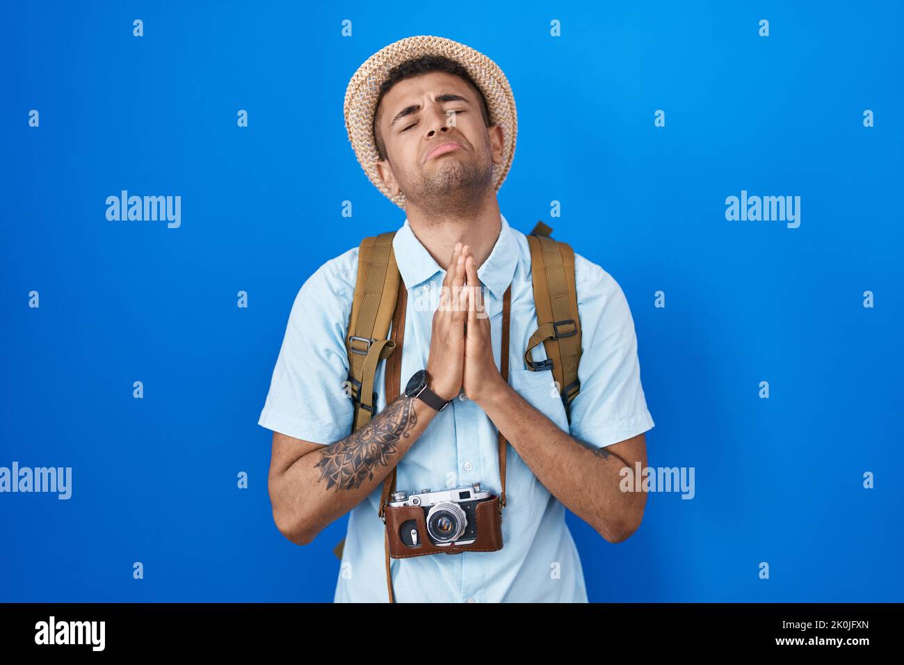 Brazilian young man holding vintage camera begging and praying with ...