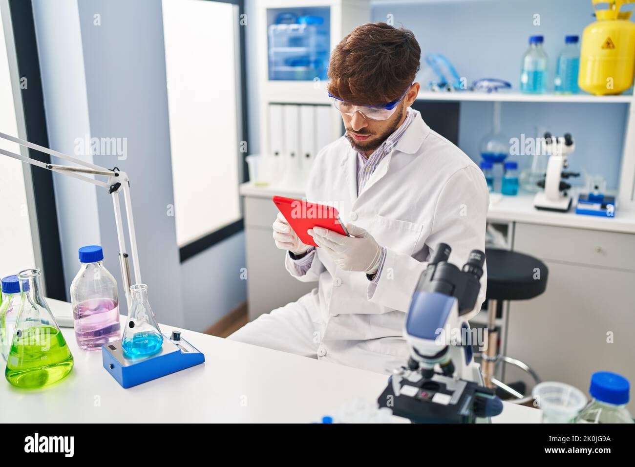 Young arab man scientist using touchpad working at laboratory Stock Photo - Alamy