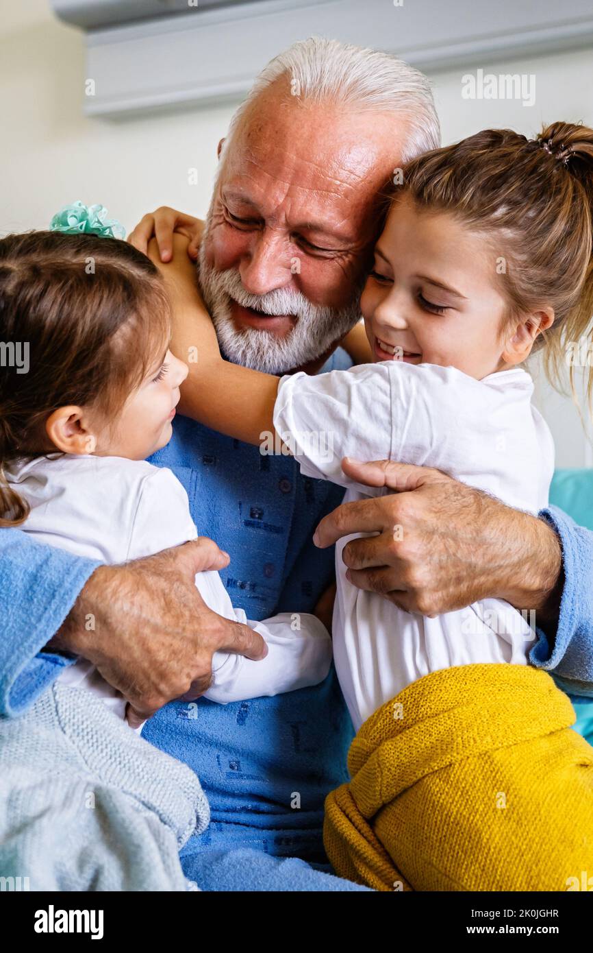 Happy laughing grandfather playing, having fun with his grandchildren ...