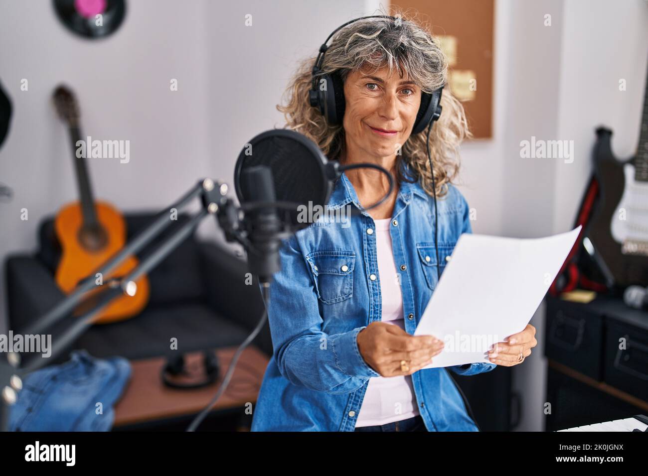Middle age woman singer singing song at music studio Stock Photo - Alamy