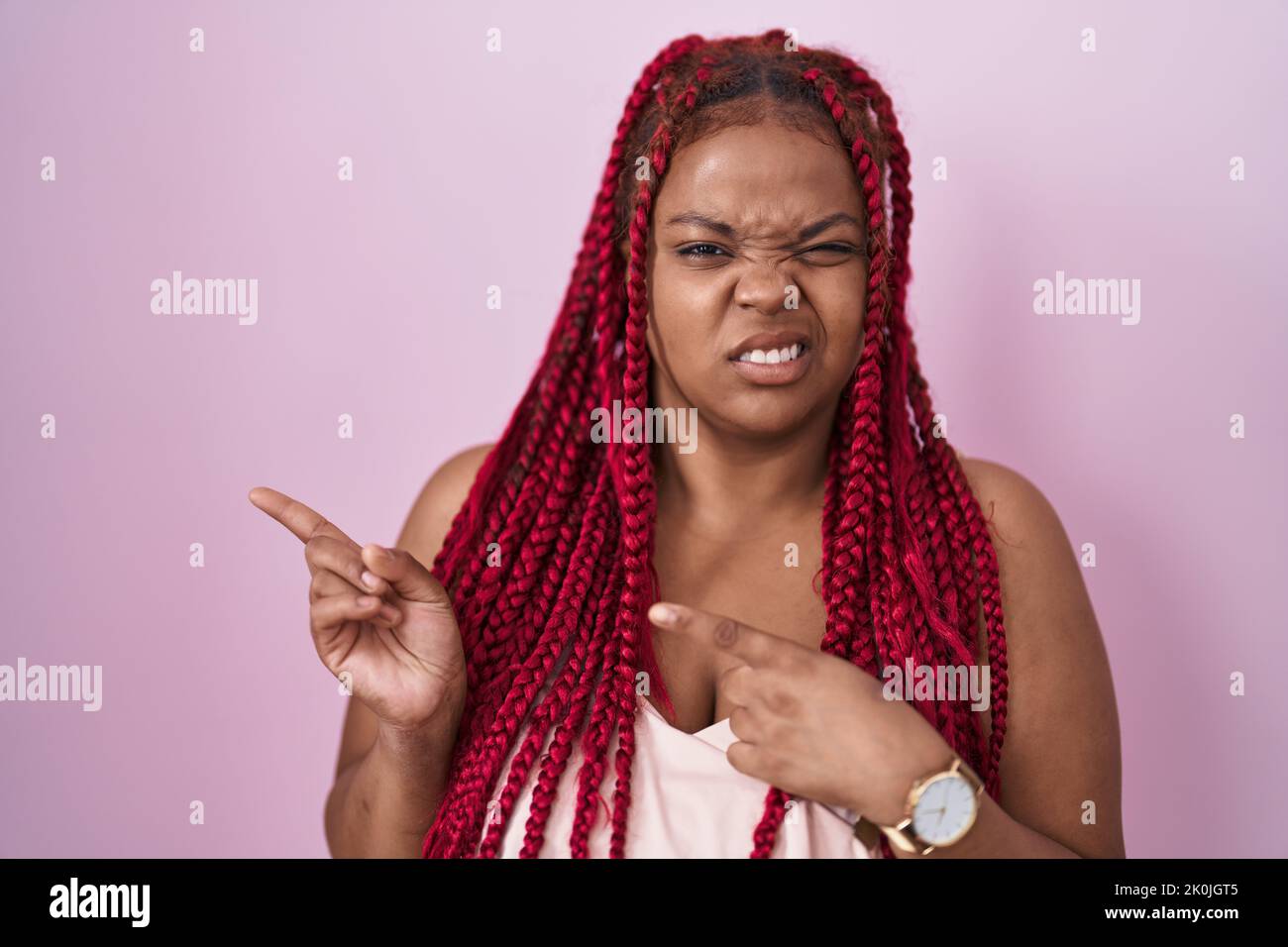 African american woman with braided hair standing over pink background ...