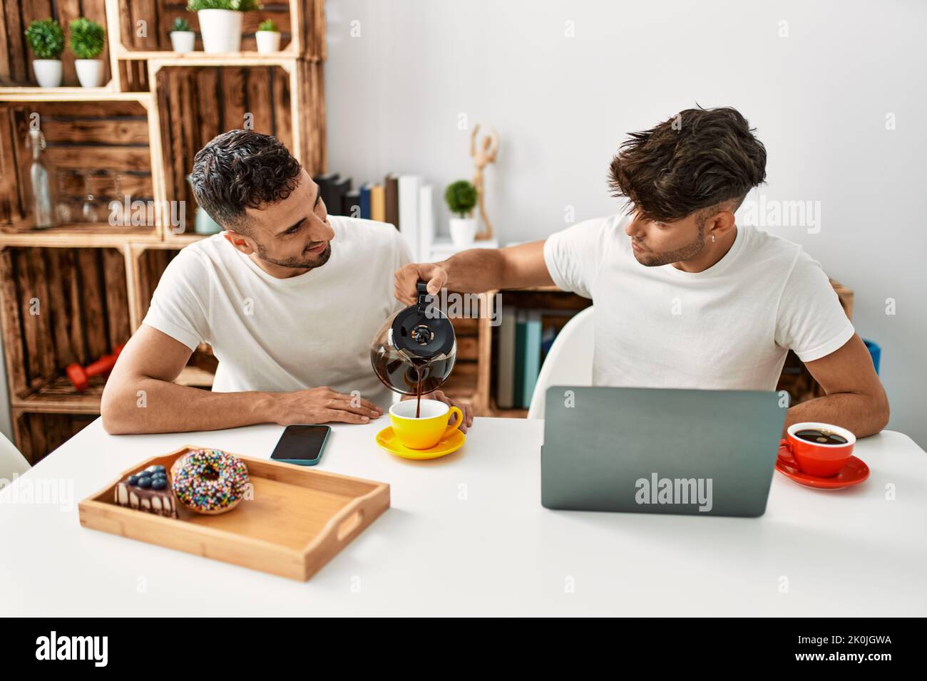 Two hispanic men couple pouring coffee having breakfast at home Stock ...