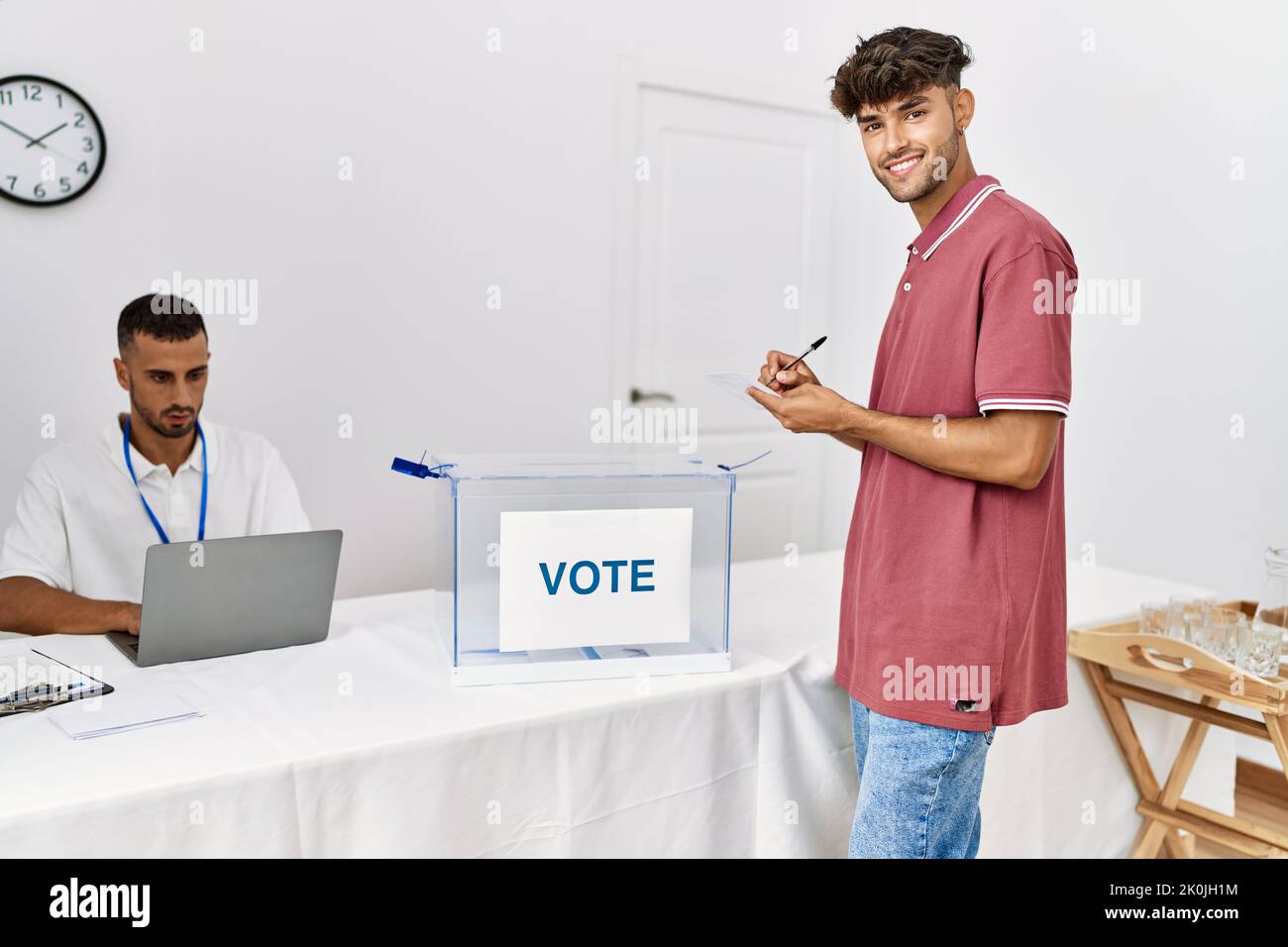 Young hispanic voter man smiling happy writing on vote at electoral ...