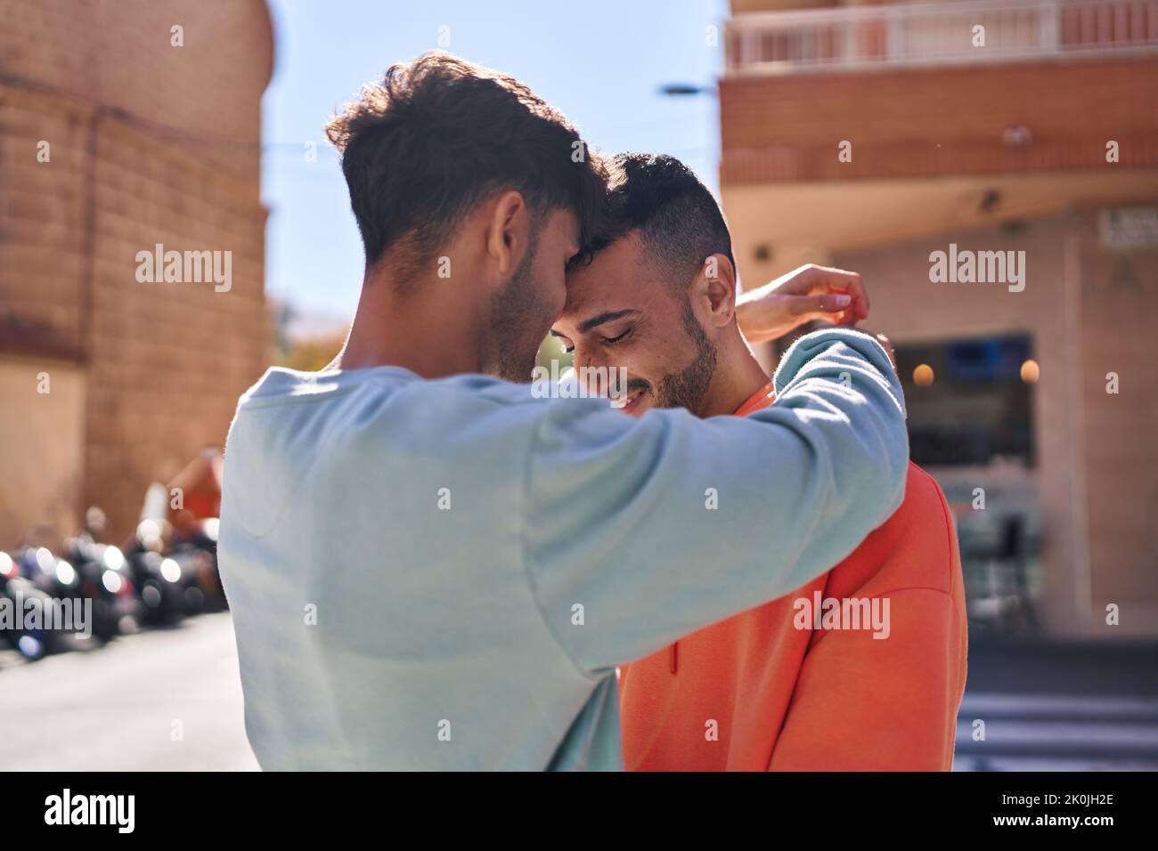 Two man couple hugging each other standing at street Stock Photo - Alamy