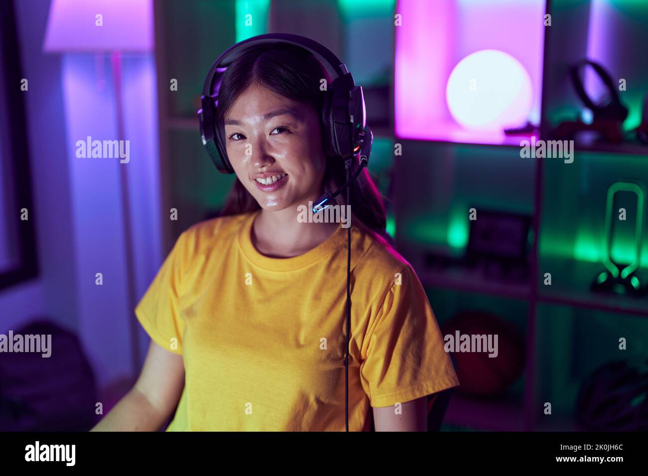 Chinese woman streamer smiling confident using headset at gaming room ...