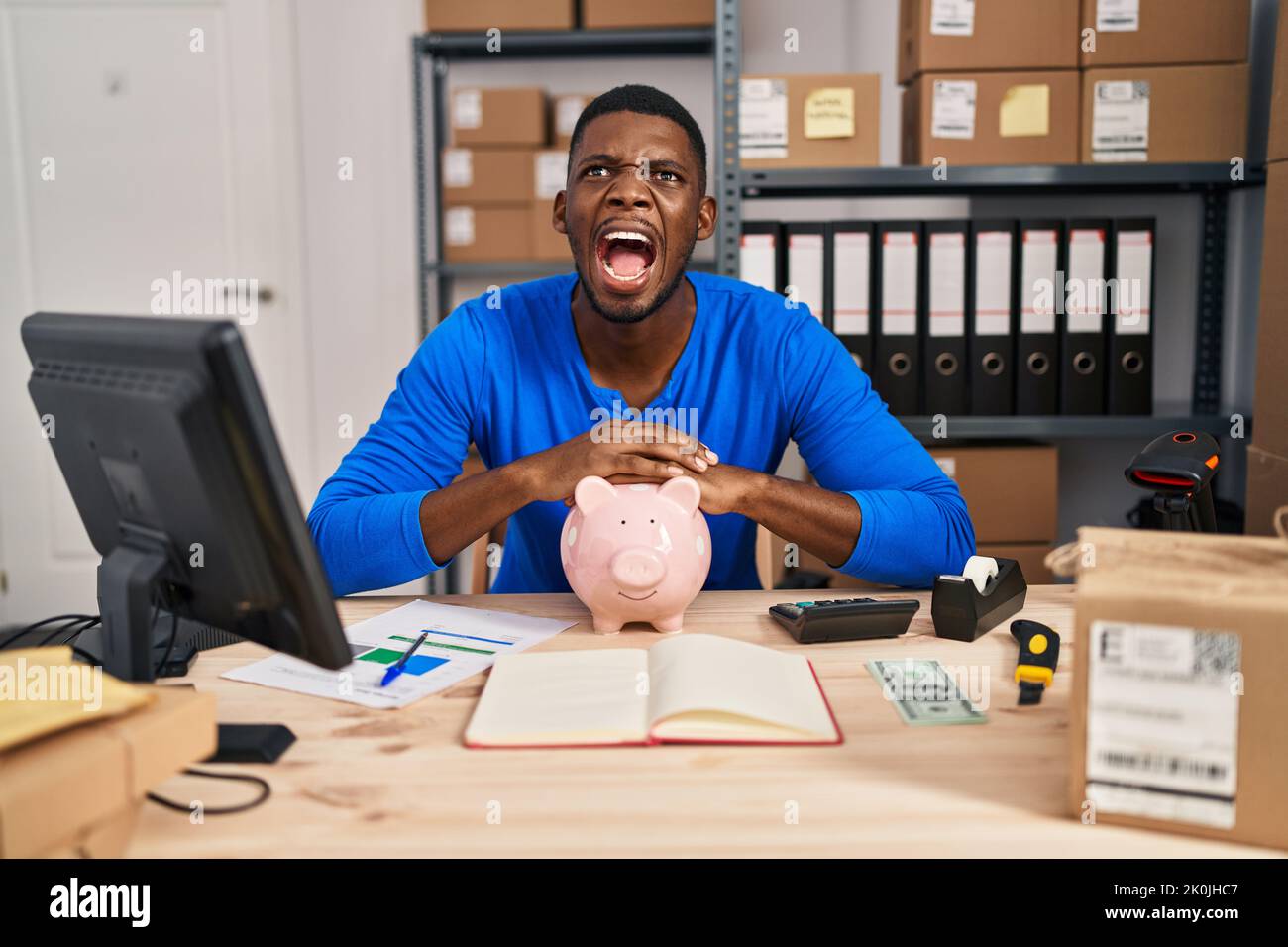 African american man working at small business ecommerce with piggy ...