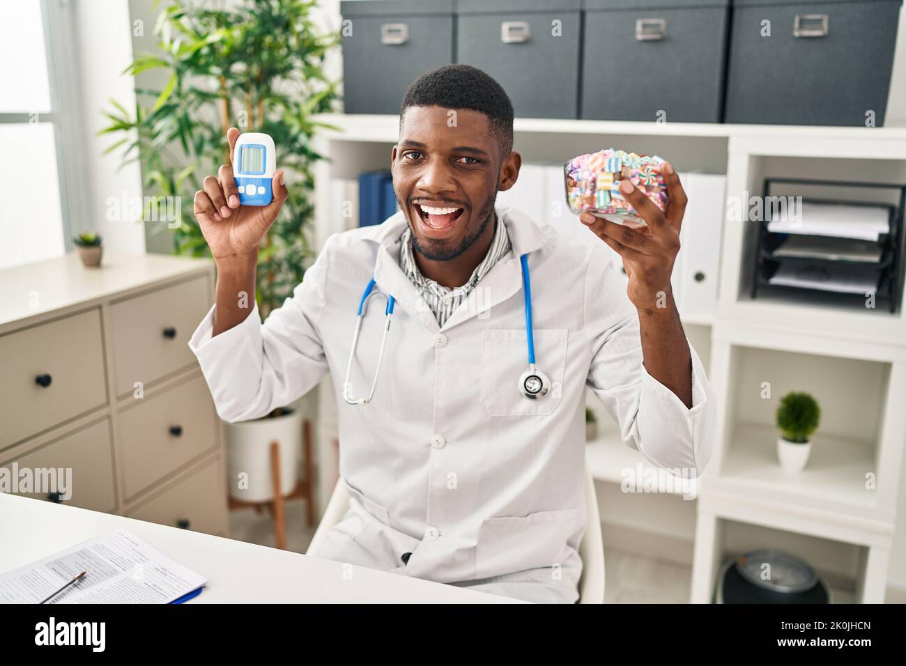 African american doctor man using glucose meter smiling and laughing ...