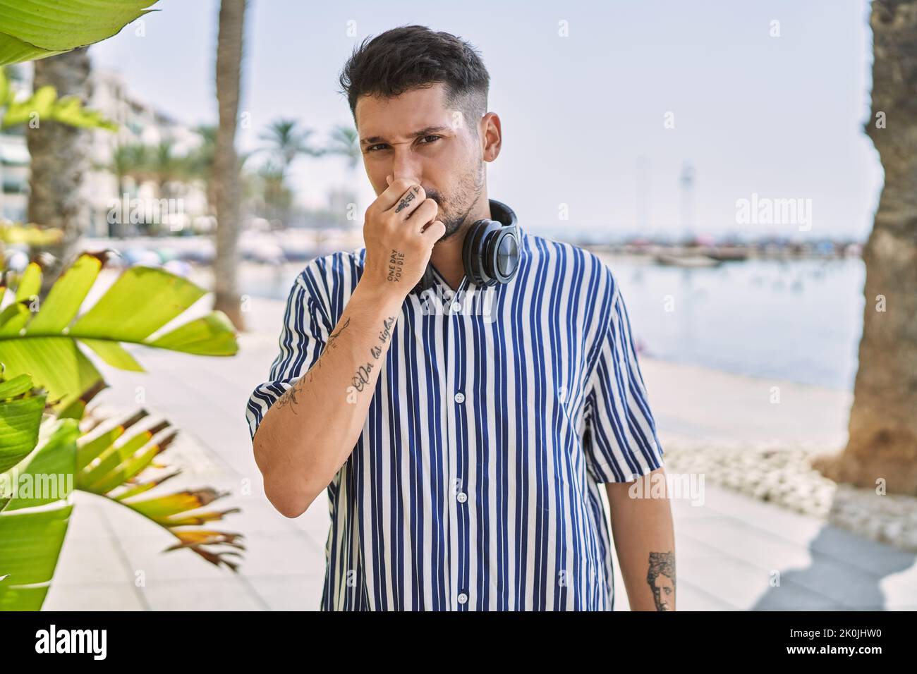 Young handsome man listening to music using headphones outdoors ...