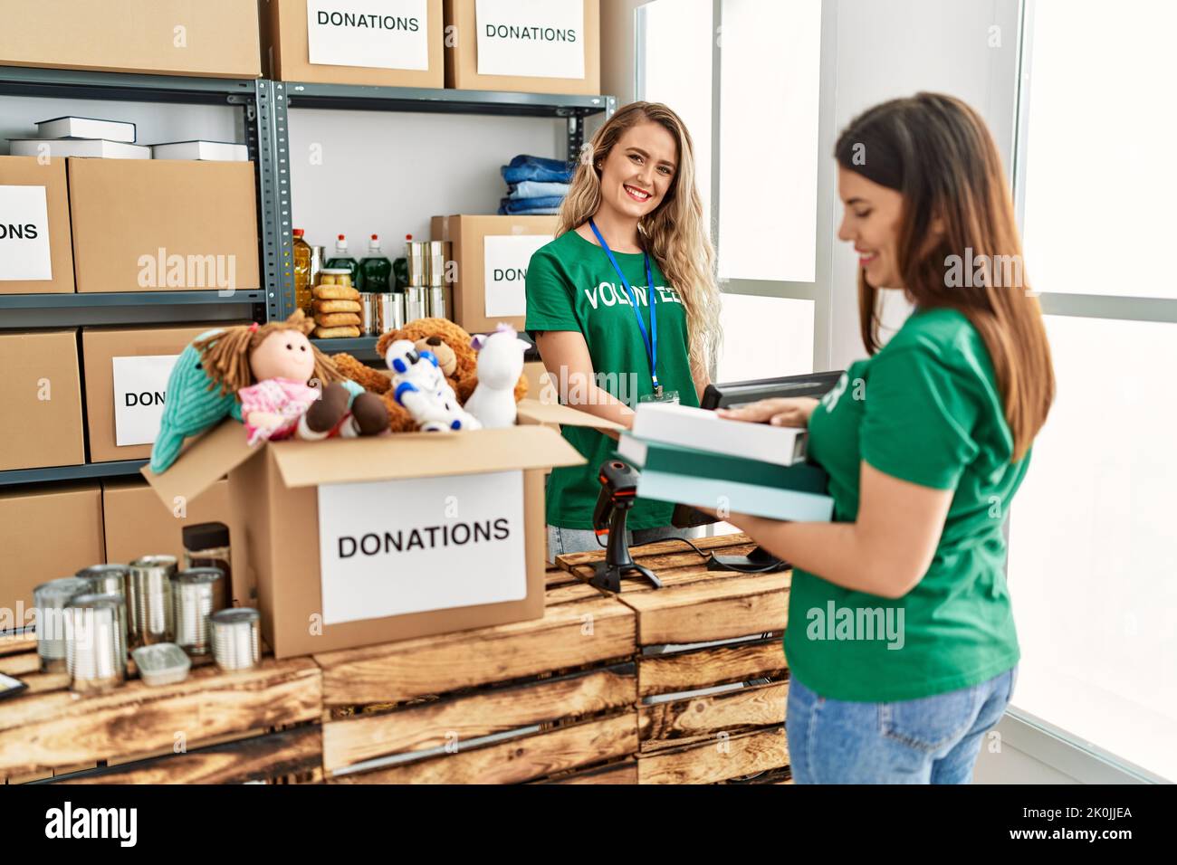 Young volunteer girl helping woman at charity center Stock Photo - Alamy