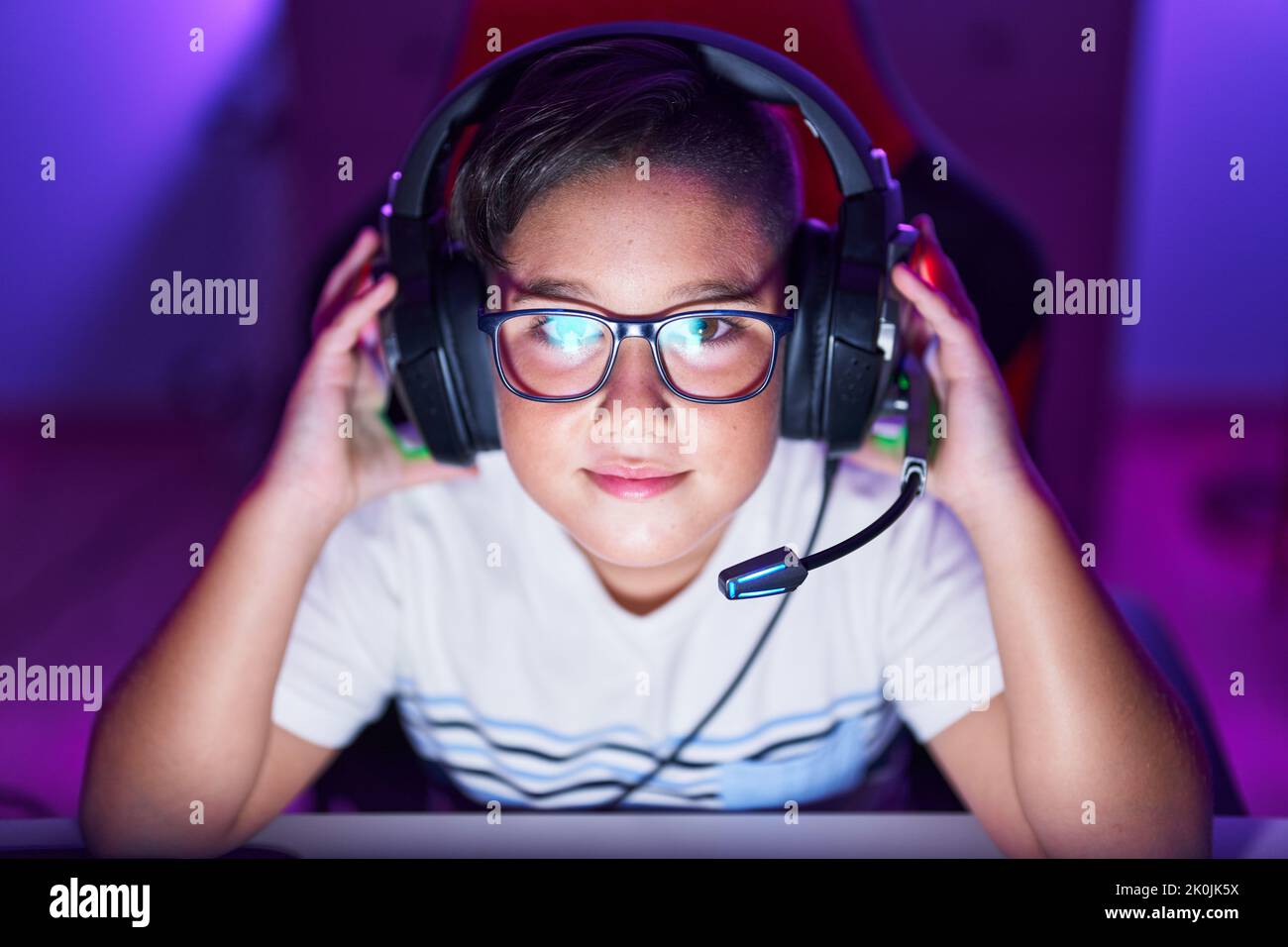 Adorable hispanic boy streamer smiling confident sitting on table at ...