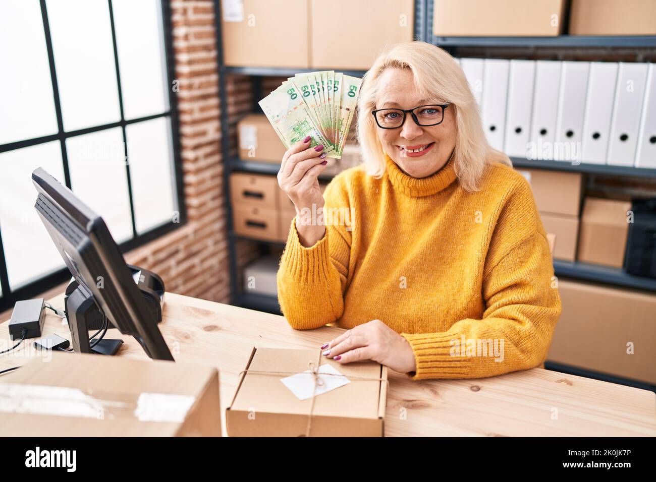 Middle age caucasian woman working at small business ecommerce holding ...