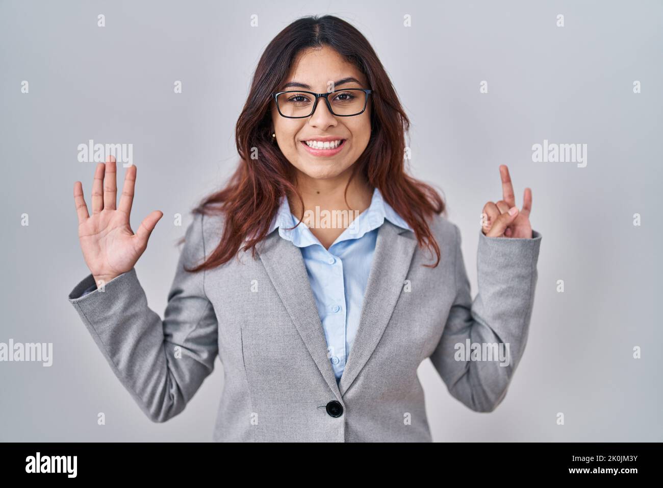 Hispanic young business woman wearing glasses showing and pointing up ...