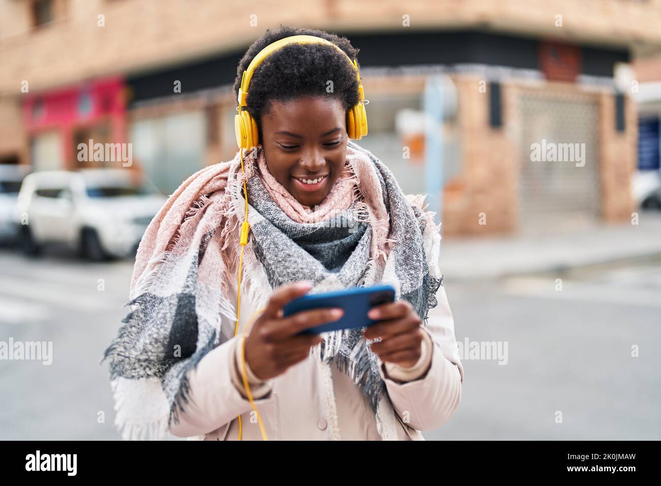 African american woman smiling confident playing video game at street ...