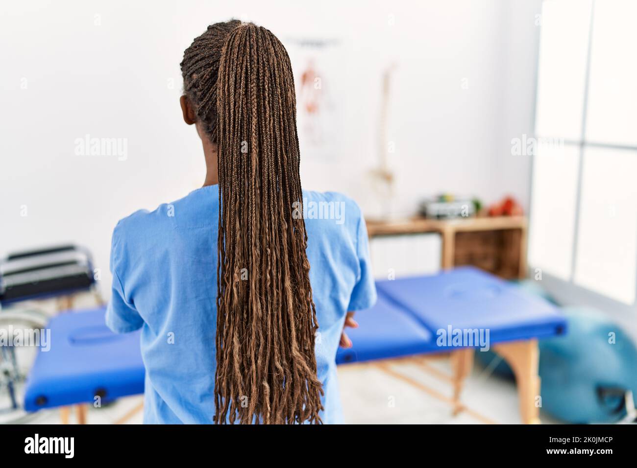 Black woman with braids working at pain recovery clinic standing ...
