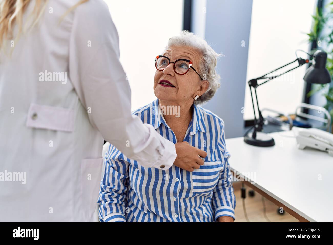 Senior grey-haired woman patient having medical consultation ...