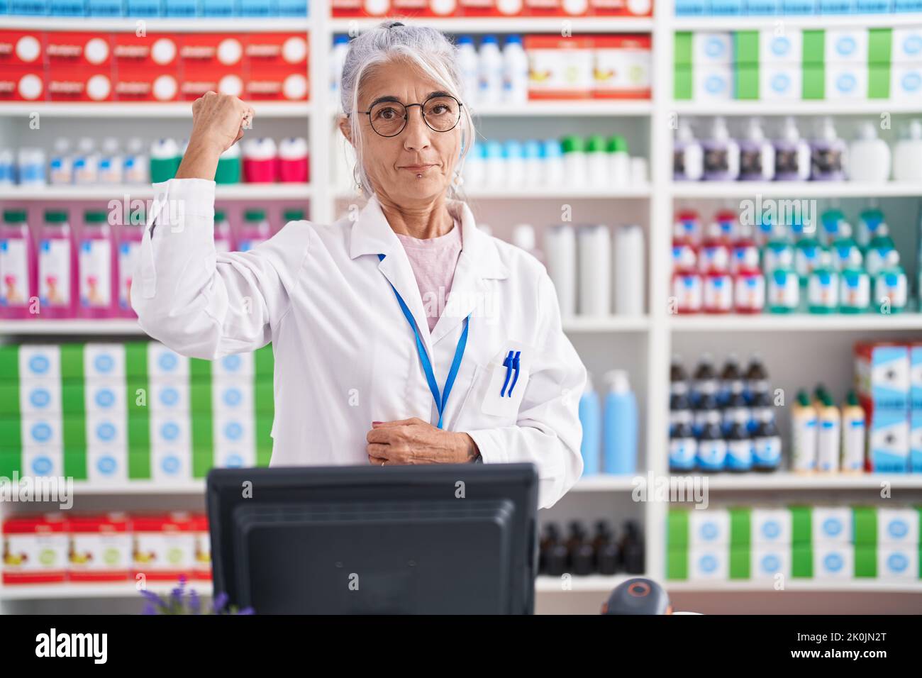 Middle age woman with tattoos working at pharmacy drugstore strong ...