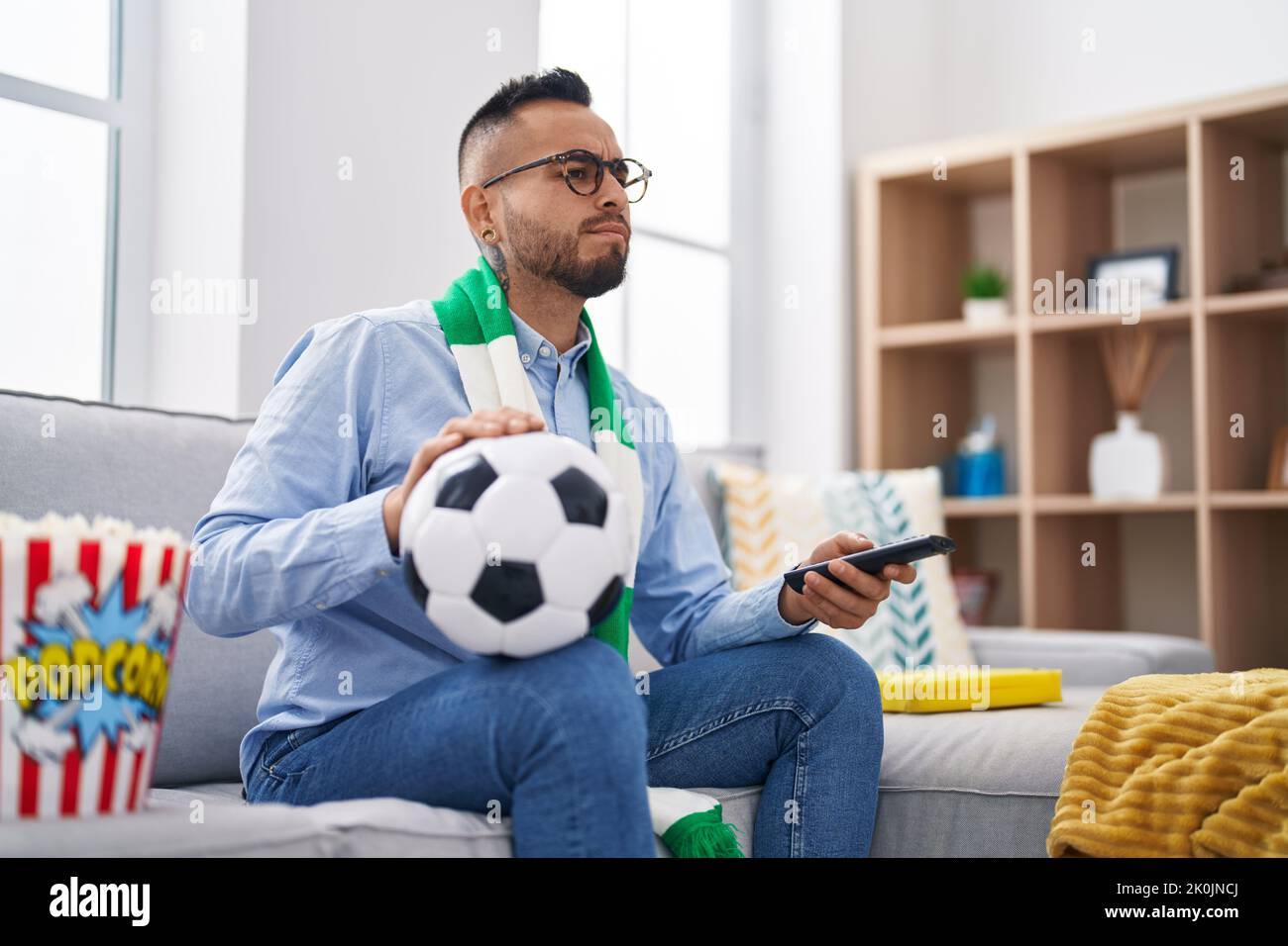 Young hispanic man football hooligan holding ball supporting team ...