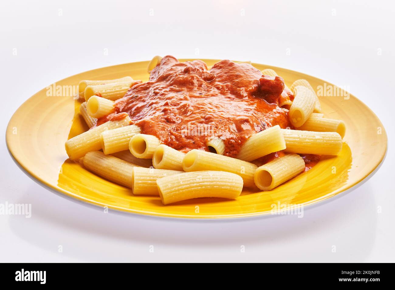 Plate of italian rigatoni pasta with tomato sauce over white isolated ...