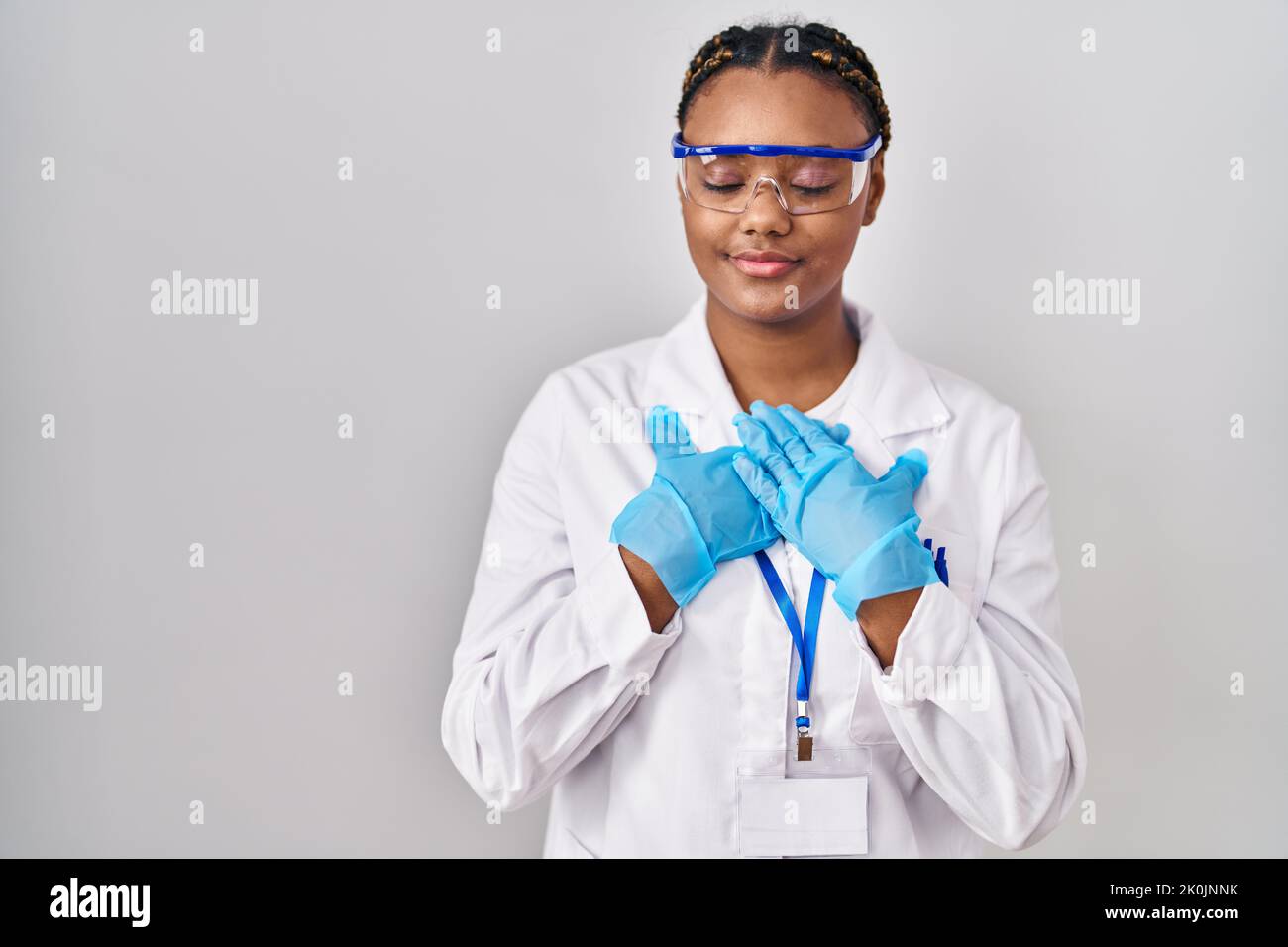 African american woman with braids wearing scientist robe smiling with ...