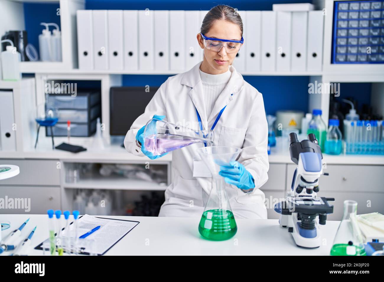 Young woman scientist measuring liquid at laboratory Stock Photo - Alamy