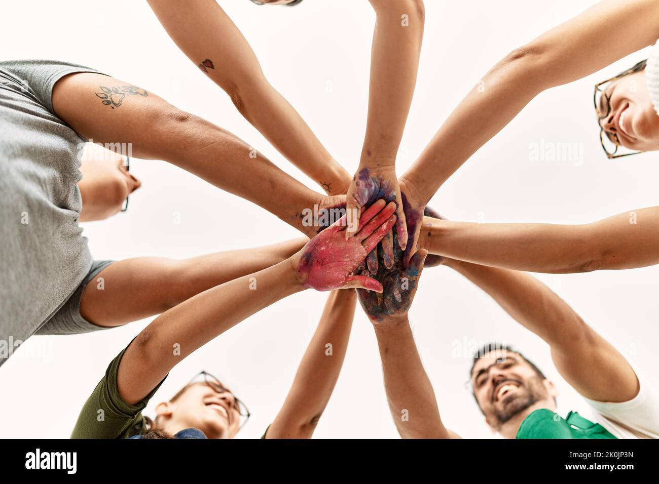 Group of people standing with united hands at art studio Stock Photo ...