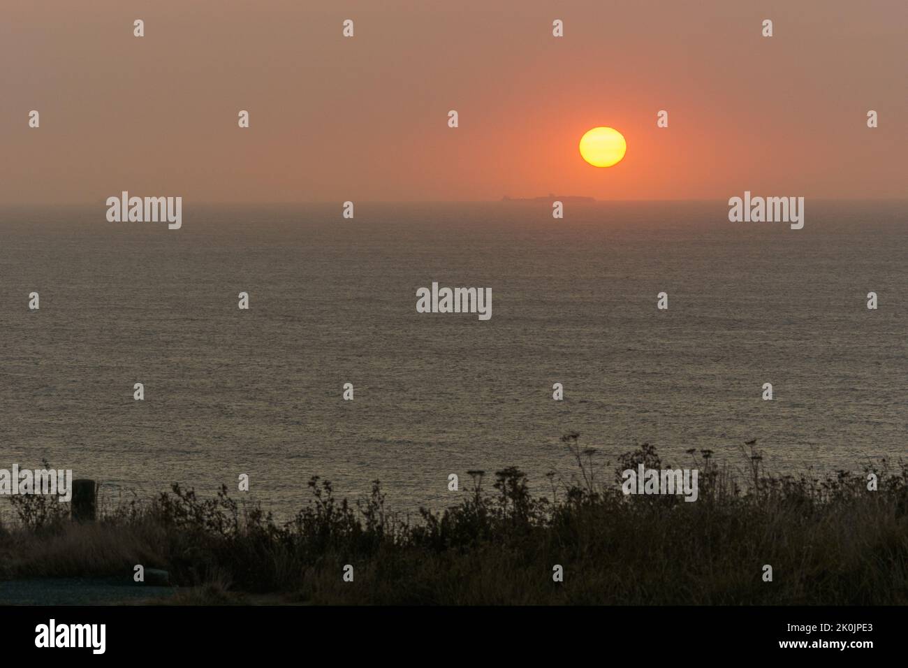 Red coloured sunset caused by thin fog on the coast of the Normandy ...