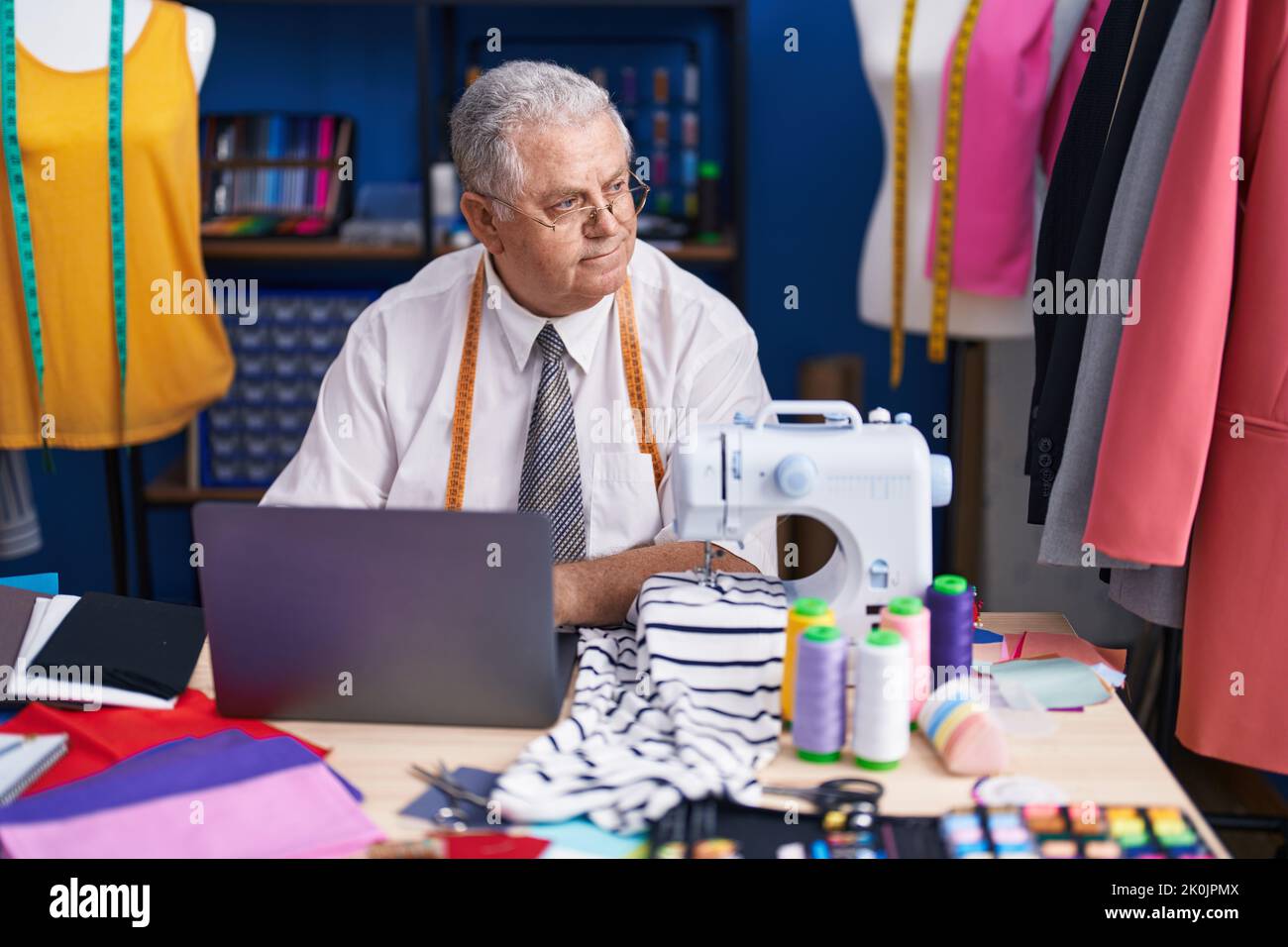 Serious handsome tailor sewing hi-res stock photography and images - Alamy