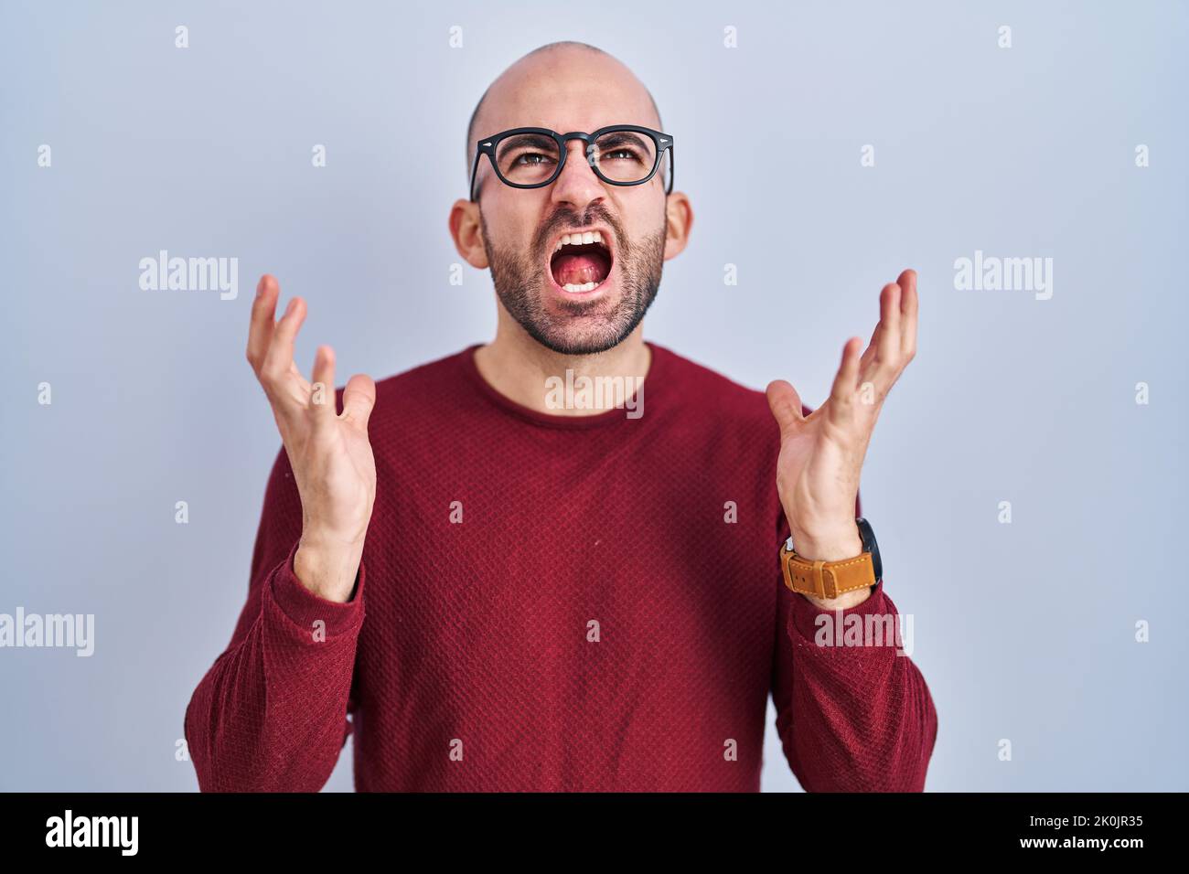 Young bald man with beard standing over white background wearing ...