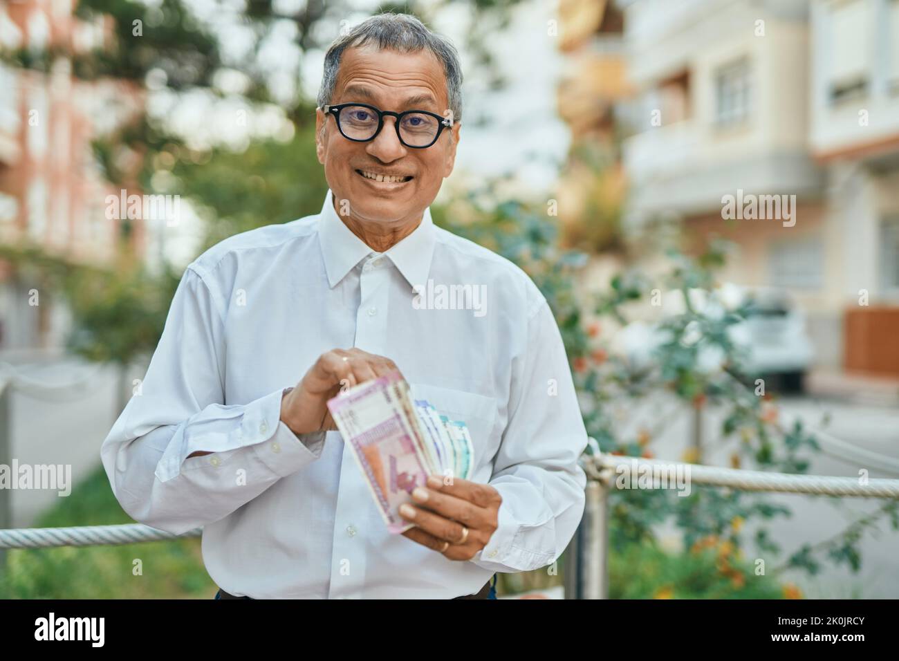 Middle age southeast asian man holding indian rupees banknotes at the ...