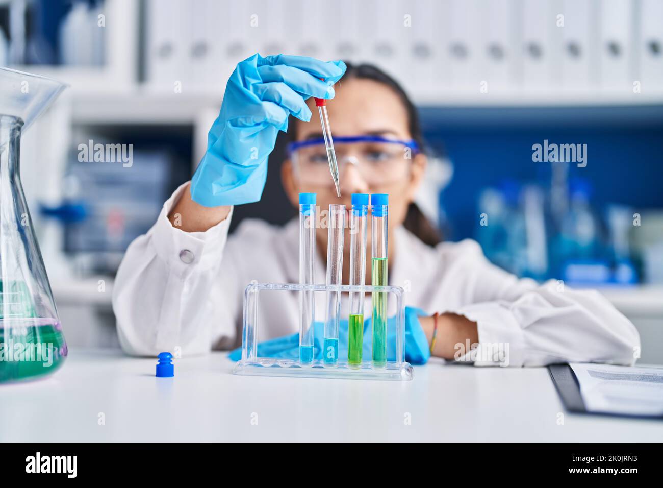 Young hispanic woman scientist measuring liquid at laboratory Stock ...