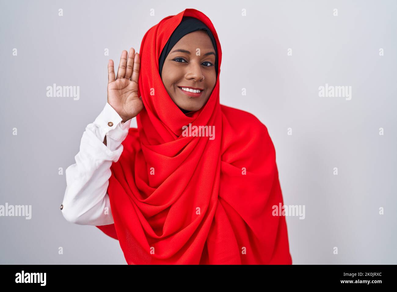 Young arab woman wearing traditional islamic hijab scarf waiving saying ...