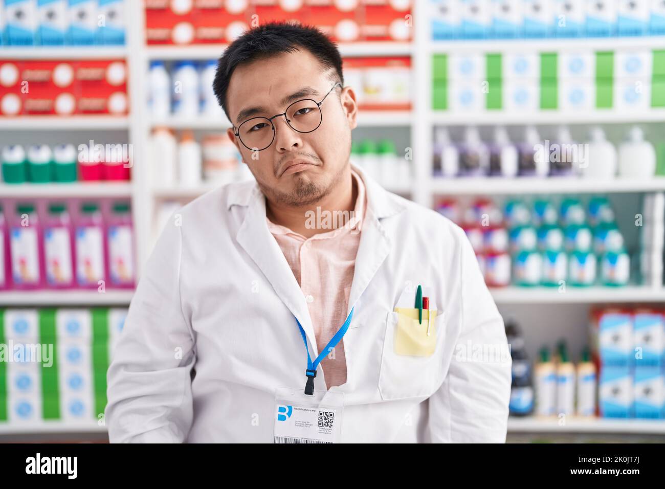 Chinese young man working at pharmacy drugstore depressed and worry for ...