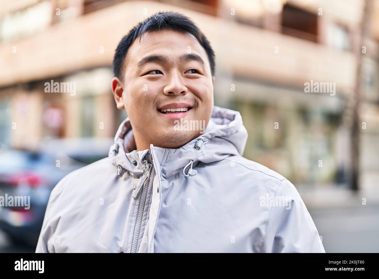 Young chinese man smiling confident standing at street Stock Photo - Alamy
