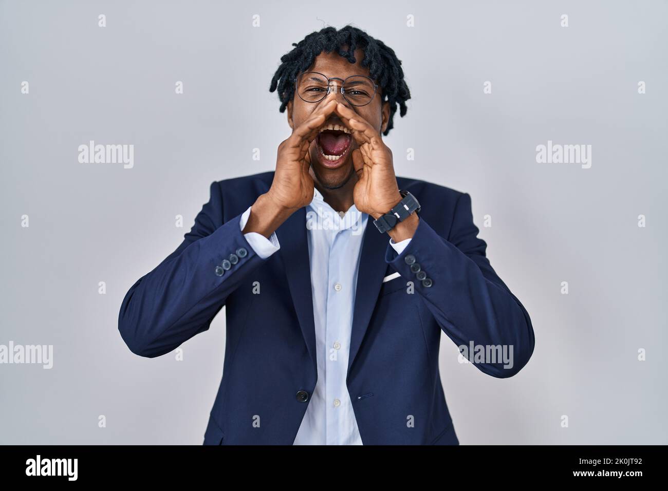 Young african man with dreadlocks wearing business jacket over white ...