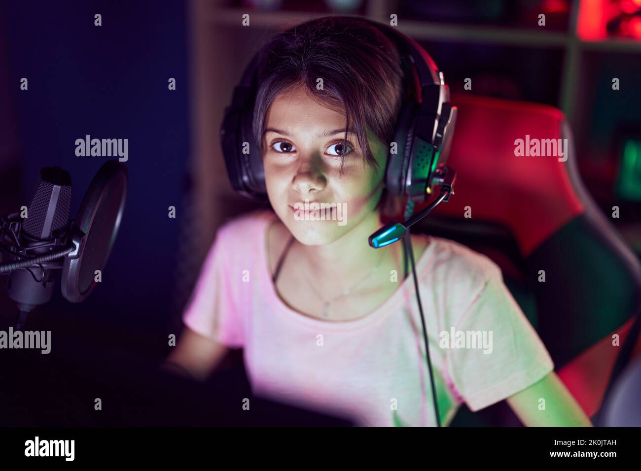 Adorable hispanic girl streamer playing video game using computer at ...