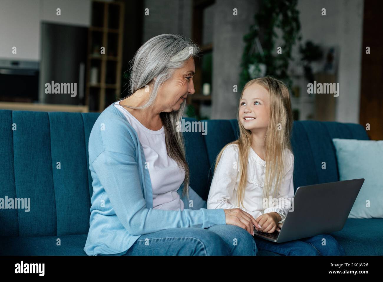 Smiling caucasian small granddaughter and old grandma have video call ...