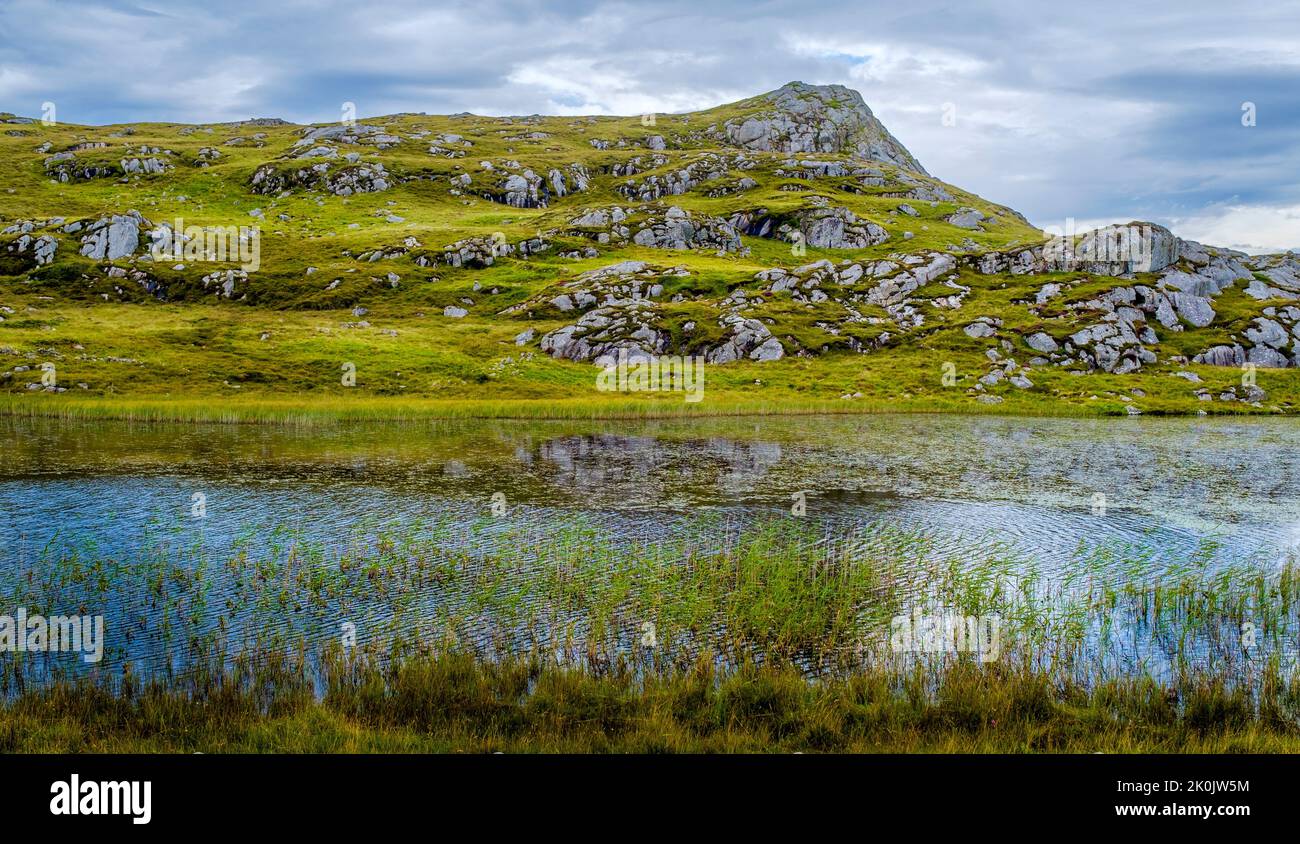Ben Hogh (106 metres) is the highest hill on Coll with Loch Ballyhaugh in the foreground Stock ...