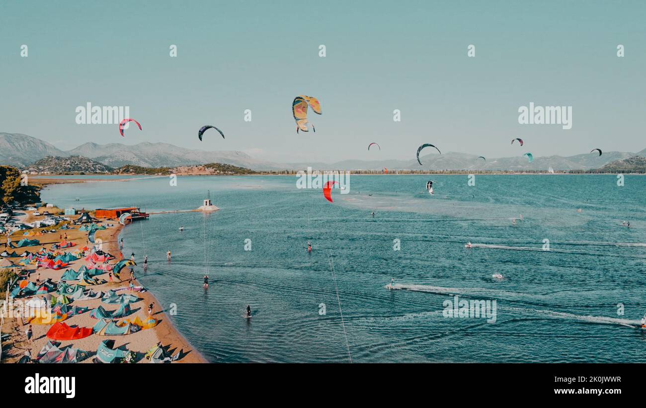 An aerial view of a group of people parachuting over a sunny seashore ...
