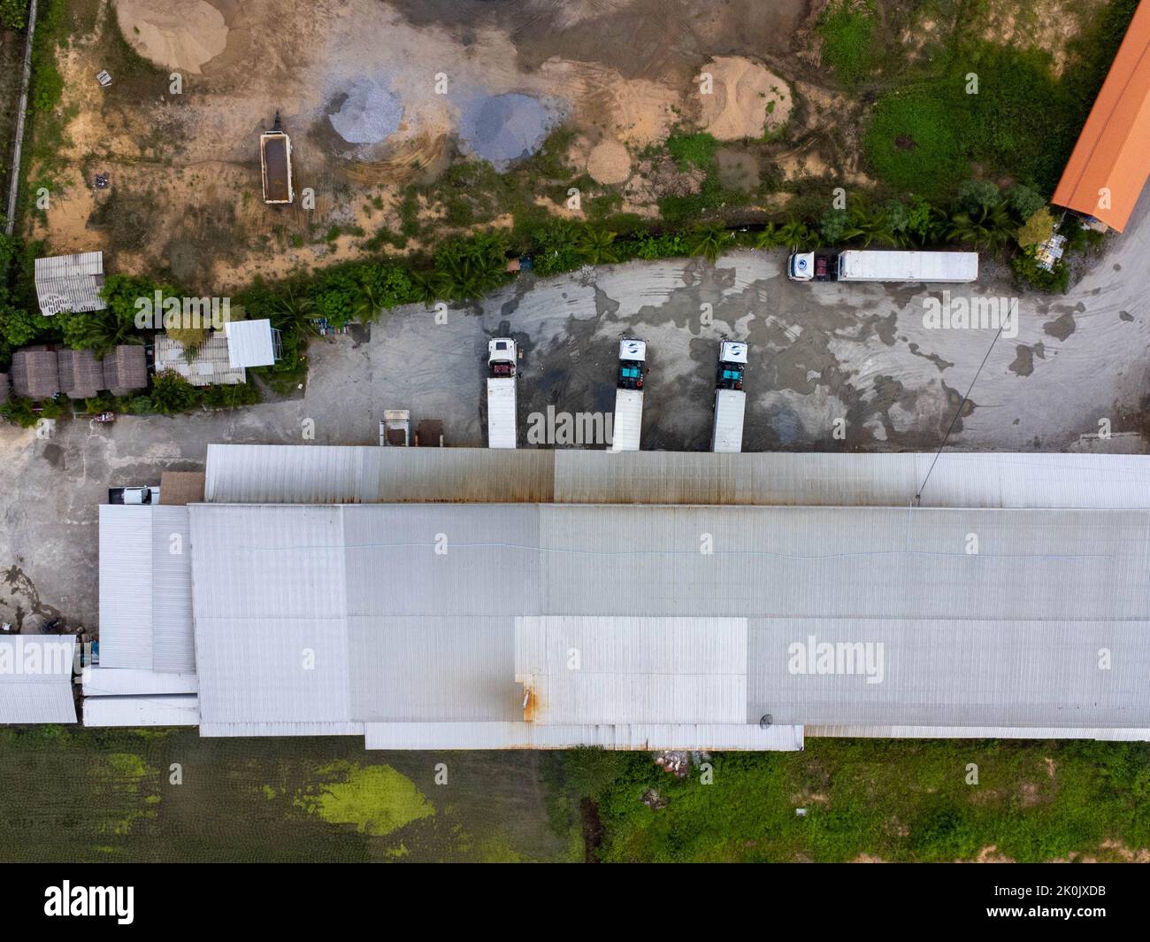 Aerial view of goods warehouse with trucks loading at logistic center ...