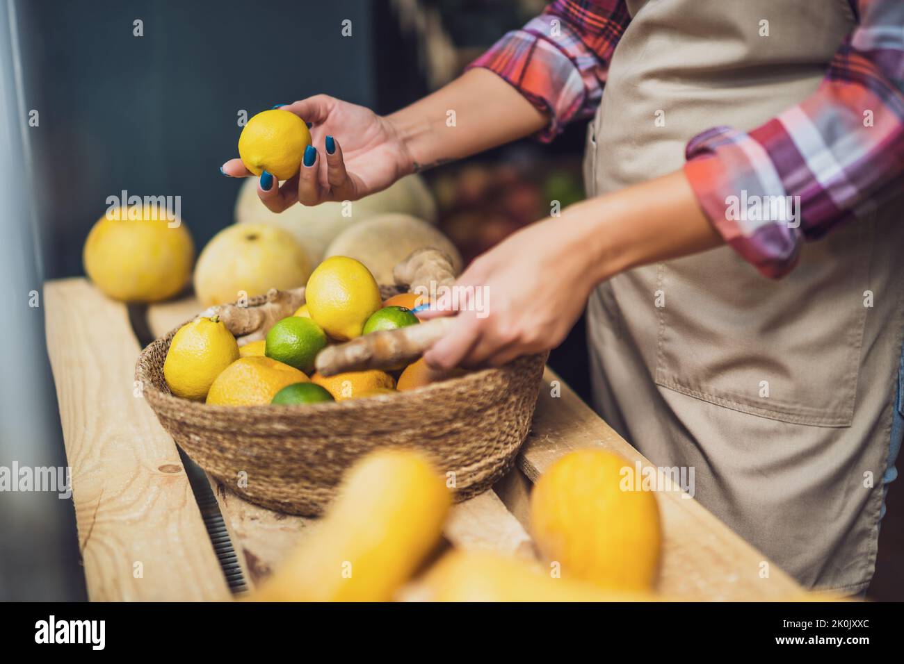 Woman works in fruits and vegetables shop. She is stacking goods in ...