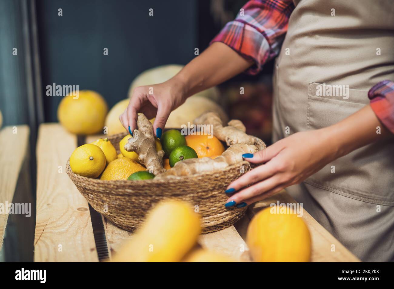 Woman works in fruits and vegetables shop. She is stacking goods in ...