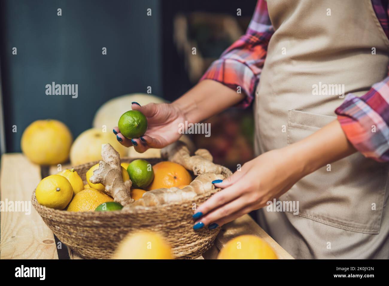Woman works in fruits and vegetables shop. She is stacking goods in ...