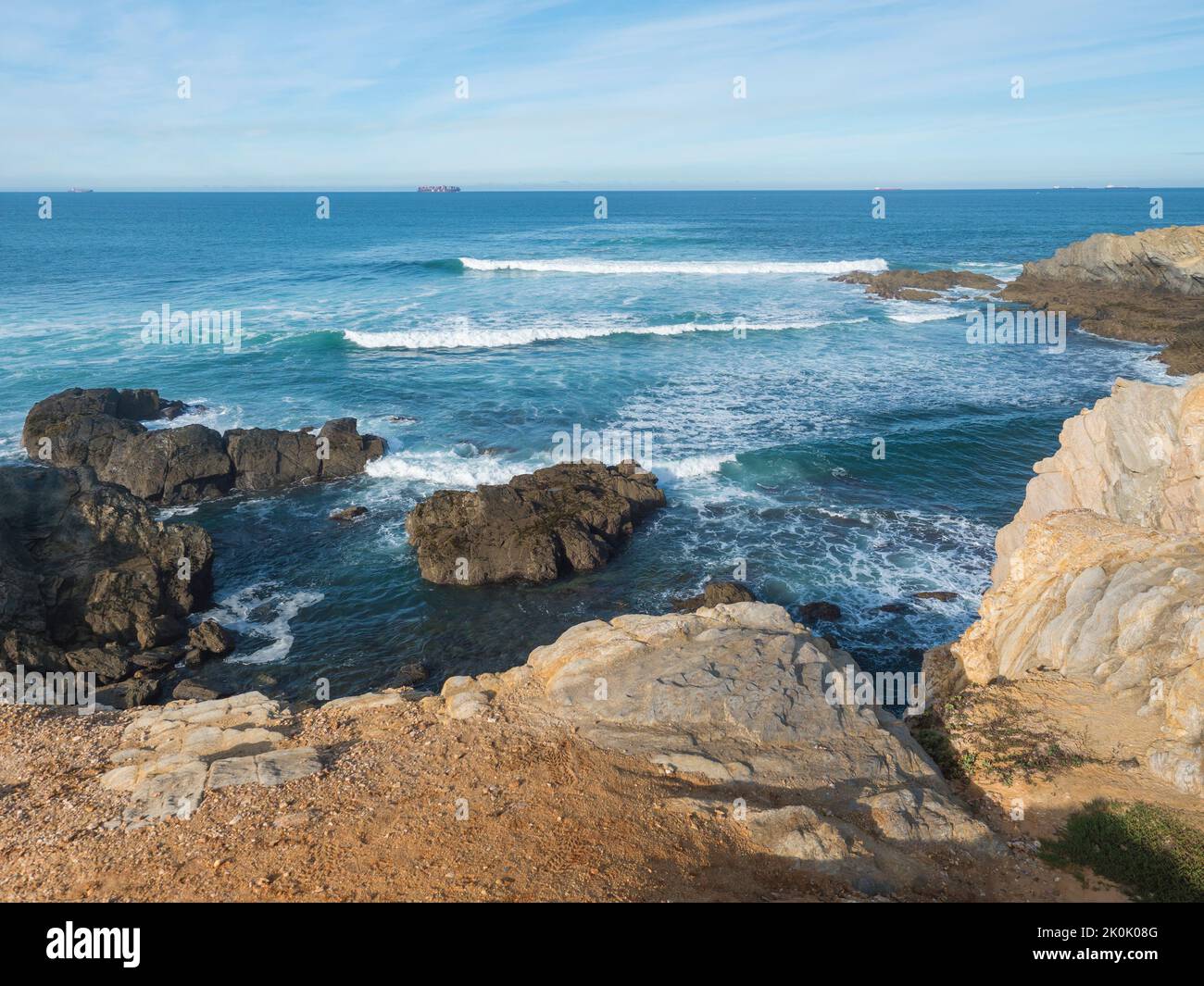 View of empty Praia Selvagem sand beach with ocean waves and sharp rock ...
