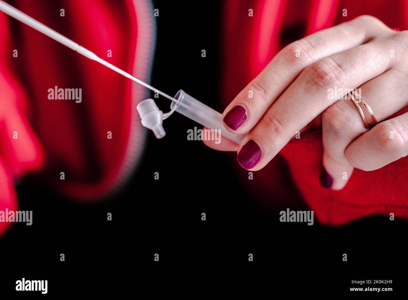 Crop anonymous sick female putting swab sample from pipette into ...