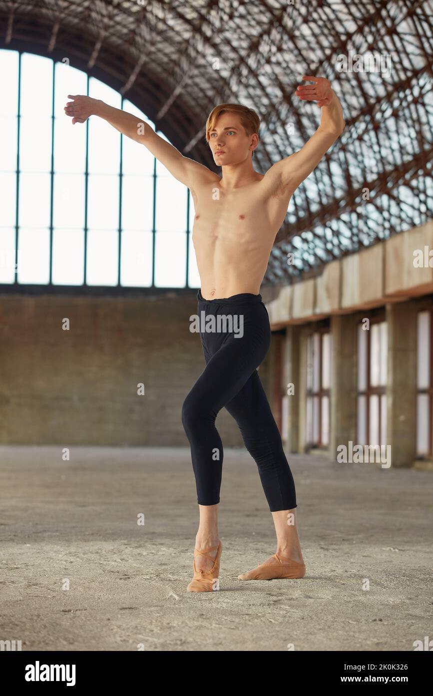 Side view of flexible young ballet dancer in leotard stretching while ...