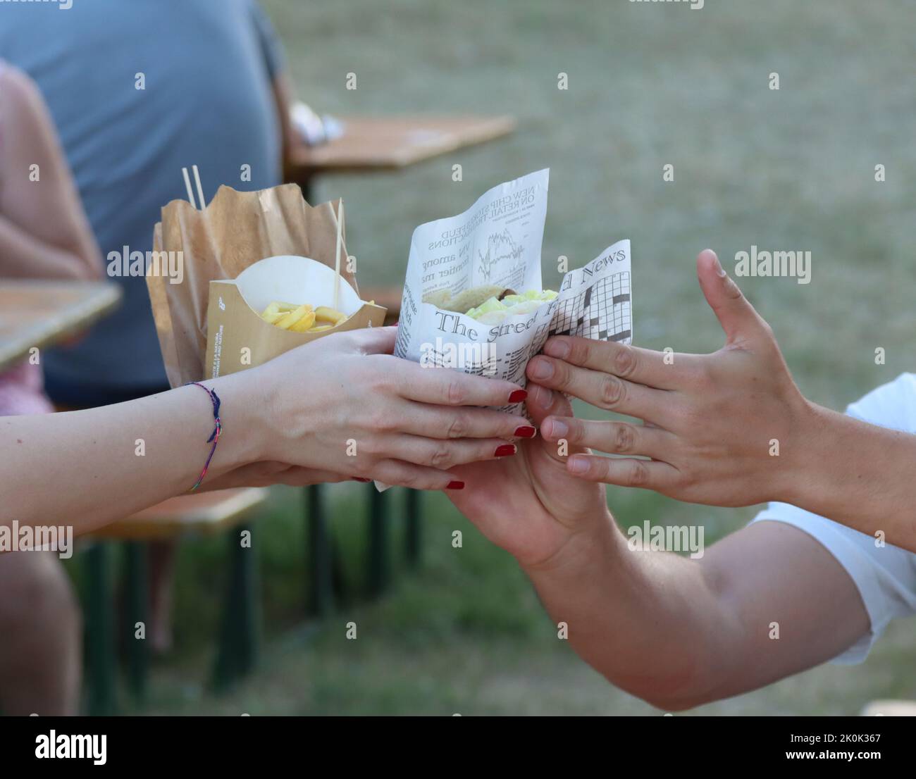 A female passing fast food to a male Stock Photo - Alamy