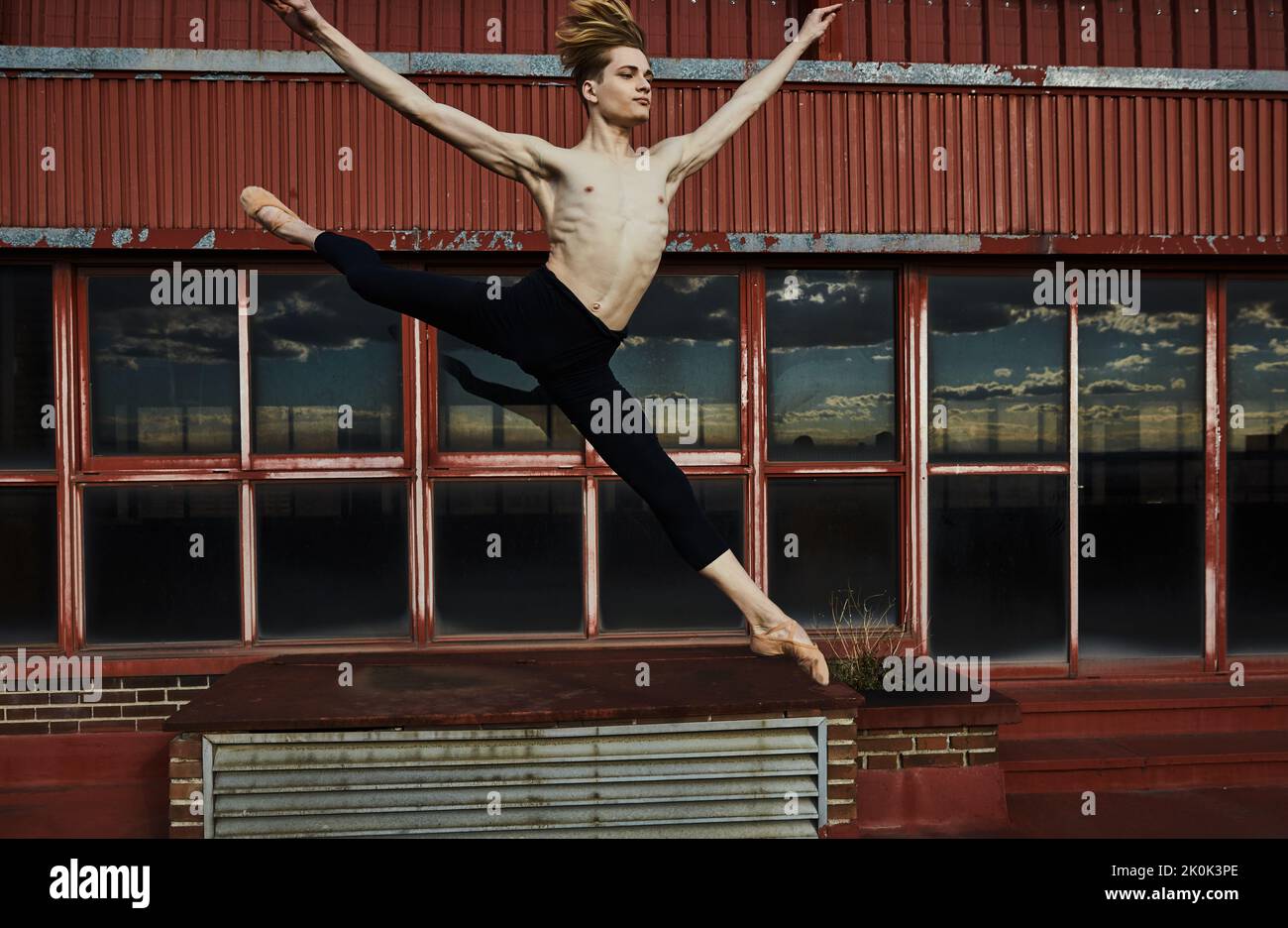 Masterful young blond ballet dancer in black leotard performing ...