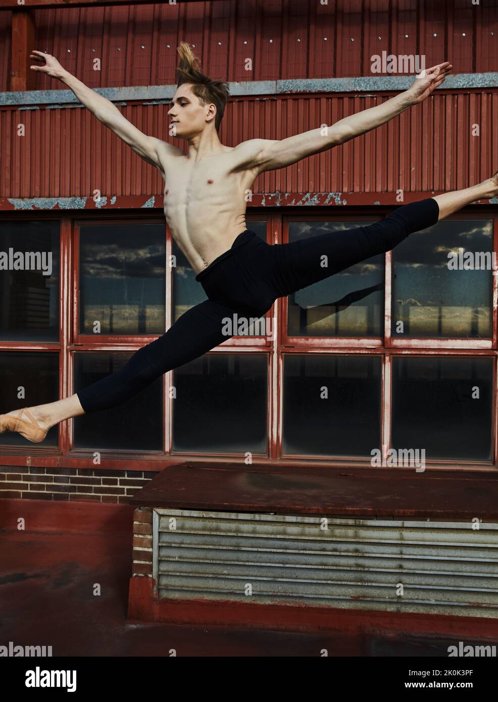 Masterful young blond ballet dancer in black leotard performing ...