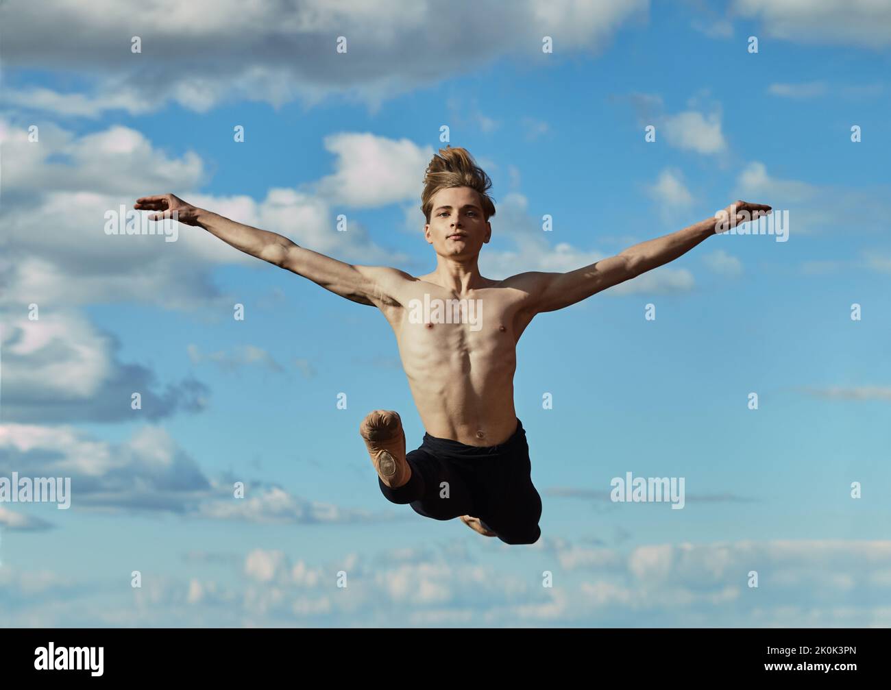 Masterful young blond ballet dancer in black leotard performing ...